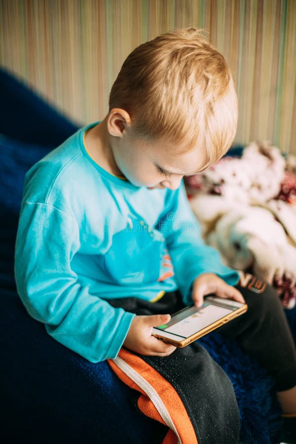 Little Blonde Boy Playing Games on Phone Stock Photo - Image of ...