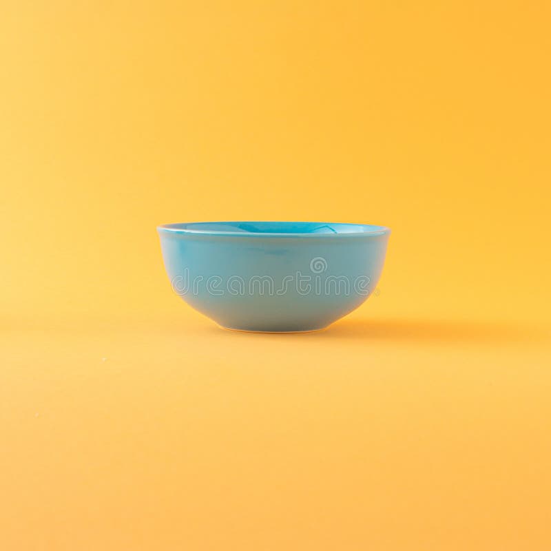 Little Blue Bowl on Ocher and Orange Background with Copy Space ... Little Blue Bowl on Ocher and Orange Background with Copy Space ...
