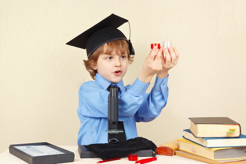 Little Boy in Academic Hat Conducts Scientific Research with Microscope ...