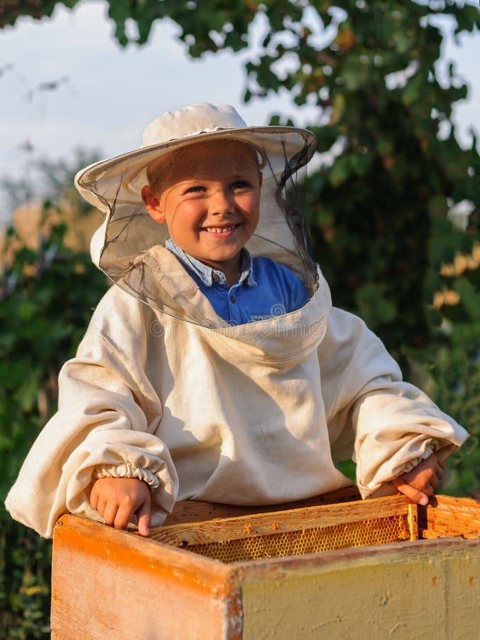 Little Boy Beekeeper Works on an Apiary at Hive Stock Photo - Image of ...