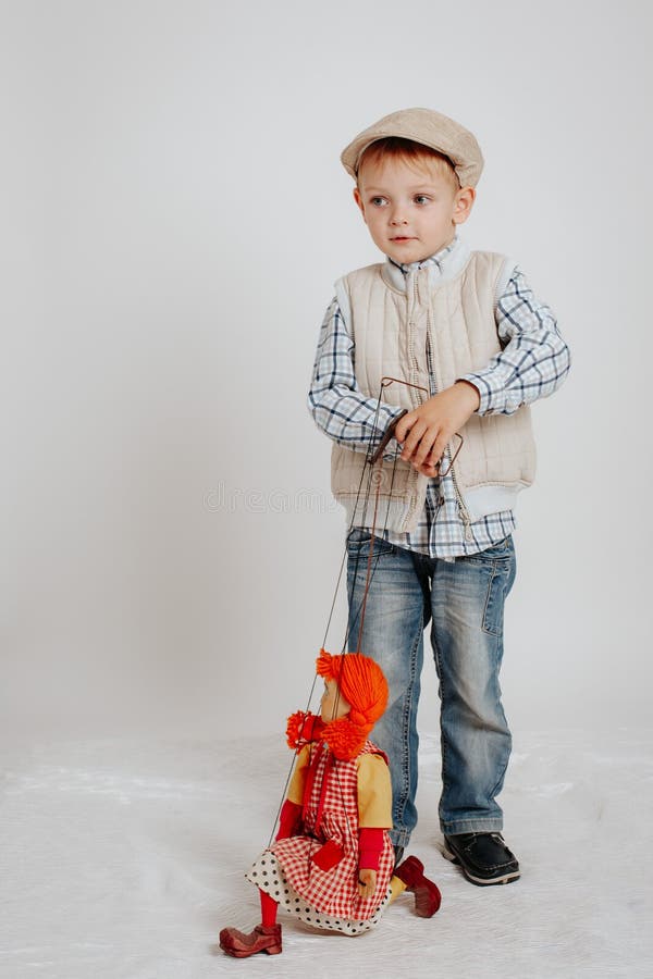 Little Boy in Cap Standing with a Puppet Doll Stock Photo - Image of ...