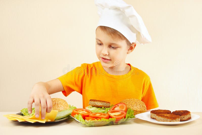 Little Boy in Chefs Hat Puts Cheese on Hamburger Stock Image - Image of ...