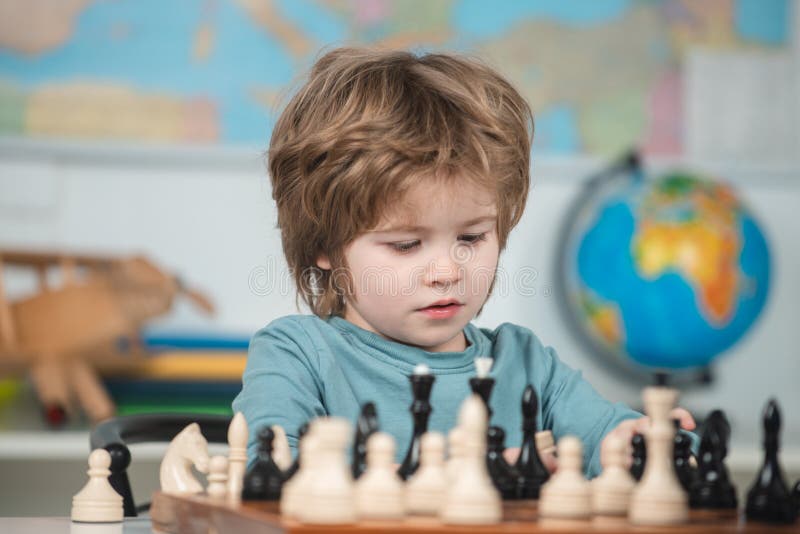 Little Boy with Chess. Concentrated Little Boy Sitting at the Table and ...