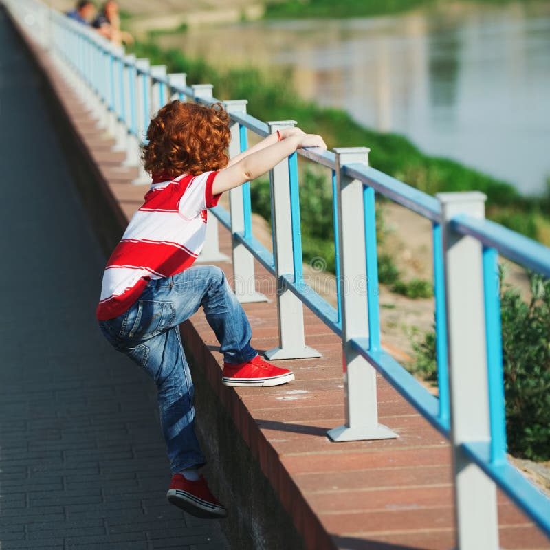 Cute Little Boy Climbing Through Fence Stock Photo - Image of caucasian ...