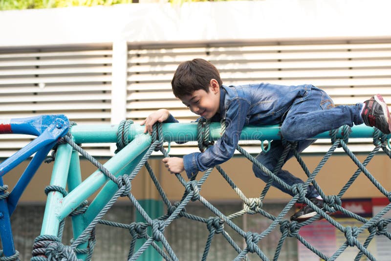 Little Boy Climbing on the Rope at Playground Outdoor Stock Photo ...