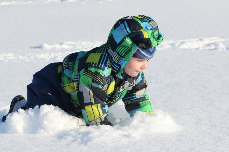 The Little Boy in a Color Jacket Creeping on Snow Stock Photo - Image ...