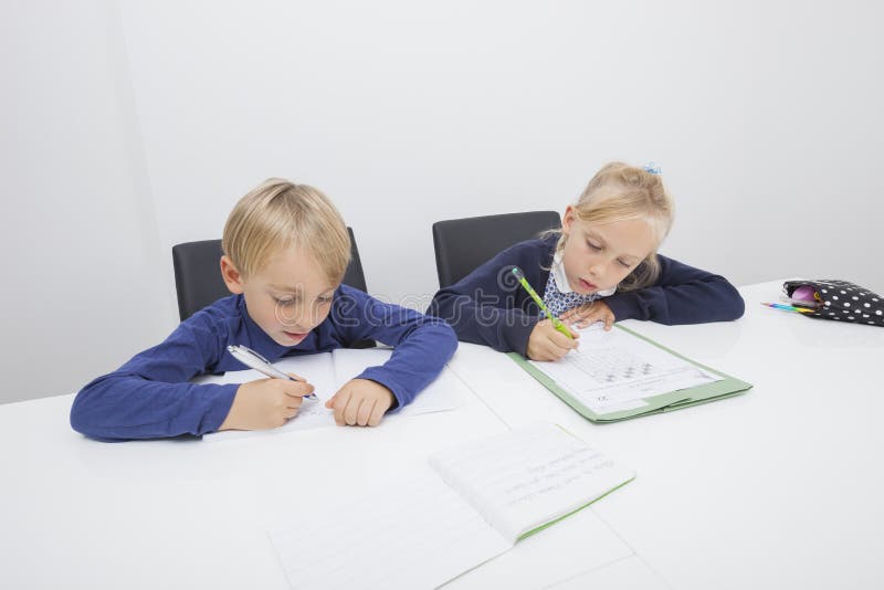 Little Boy and Daughter Writing on Documents at Table Stock Photo ...