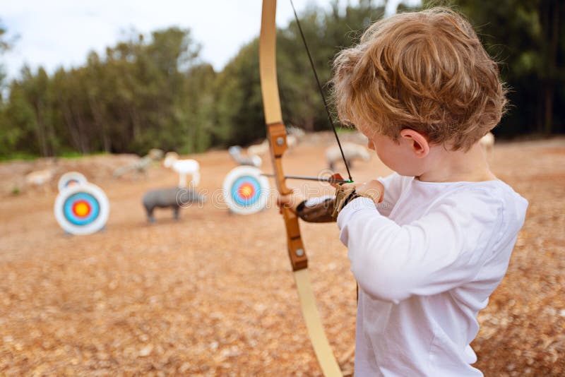 Kid practicing archery stock photo. Image of concentrated - 138164274