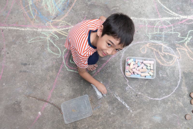 Little Boy Drawing and Coloring by Chalk on the Floor Stock Photo ...