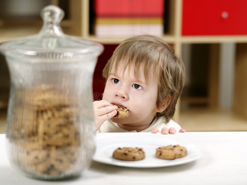 Little boy eating cookies stock photo. Image of plate - 29572022