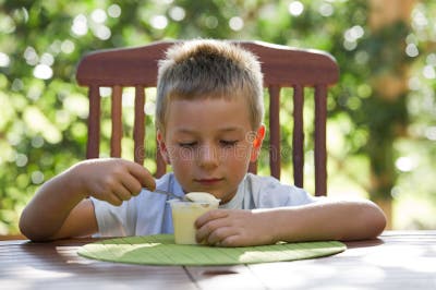Little boy eating pudding stock photo. Image of table - 16870886