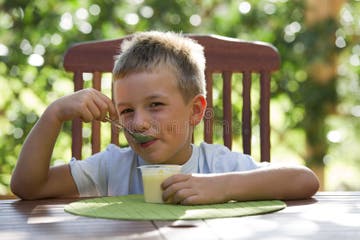 Little boy eating pudding stock photo. Image of male - 16870920