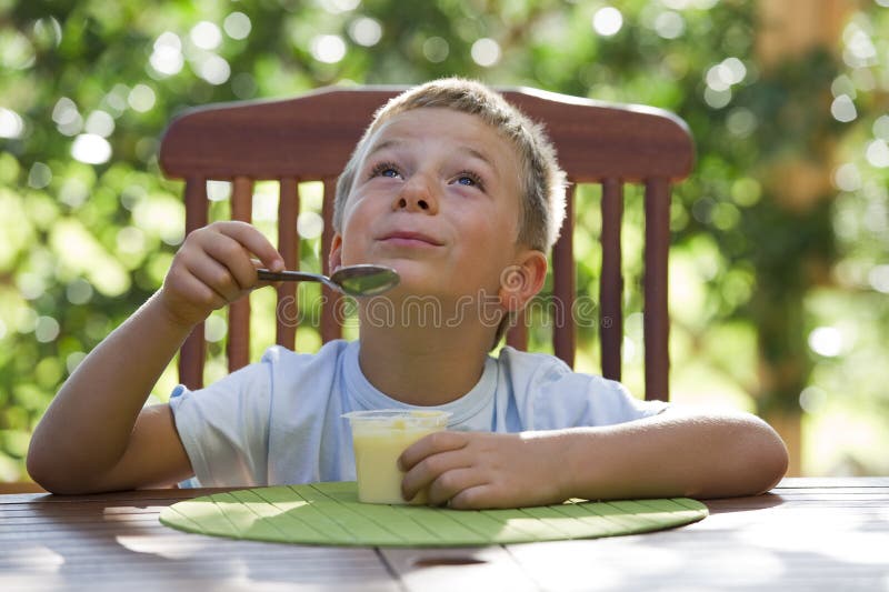 Little boy eating pudding stock photo. Image of cream - 16871074