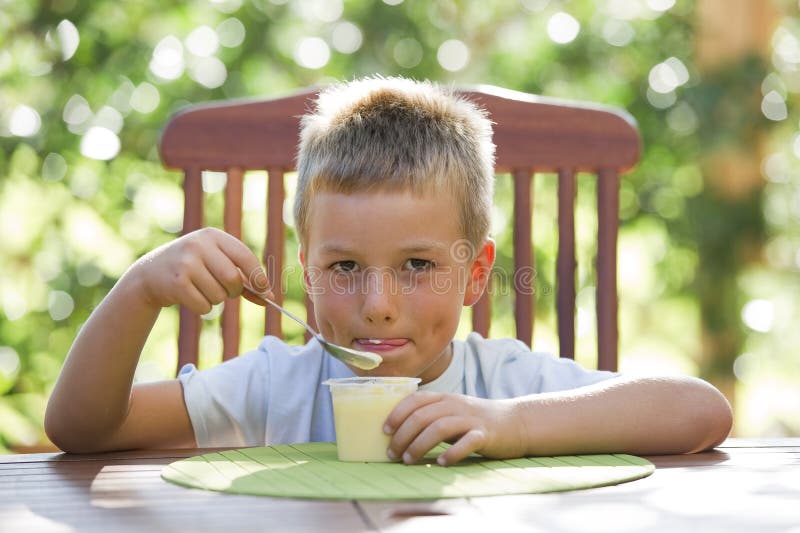 Little boy eating pudding stock photo. Image of cream - 16871074