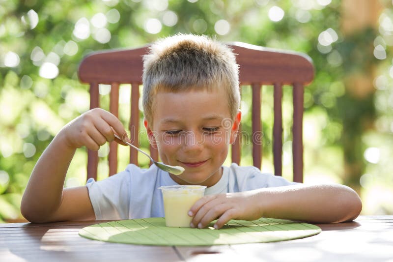Little boy eating pudding stock photo. Image of cream - 16871074