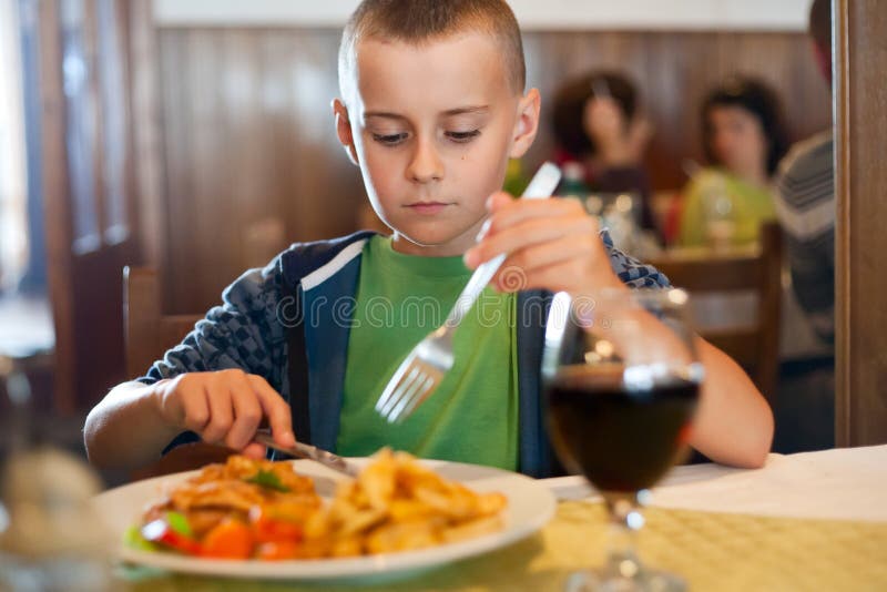 Little Boy Eating in a Restaurant Stock Image - Image of dinner, summer ...