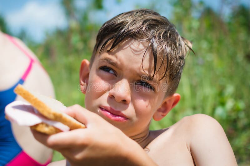 A Little Boy Eats Food on the Beach after Swimming Stock Image - Image ...