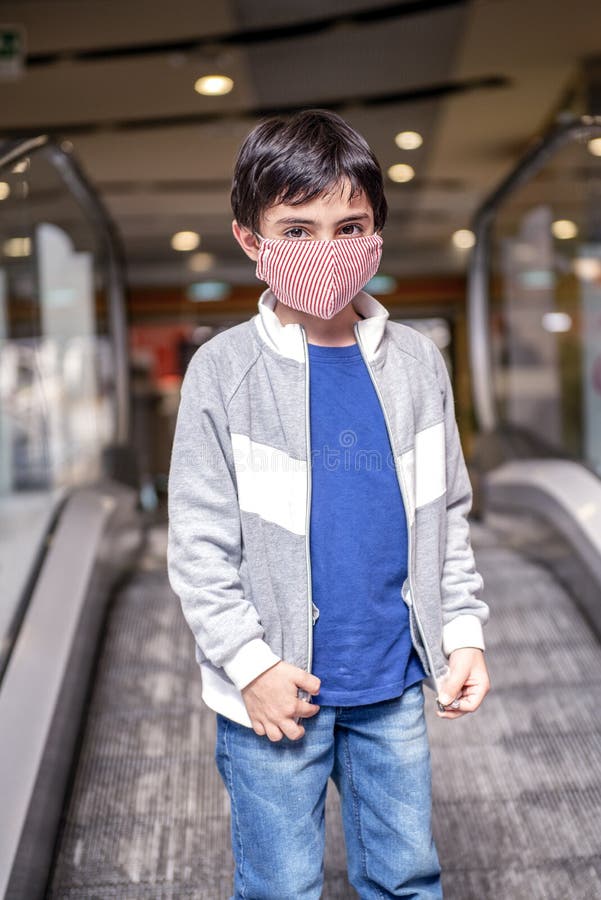 Little Boy on Escalators of a Department Store Wearing a Protective ...