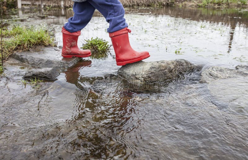 Little Boy Exploring the Country Protected with Red Rainboots Stock ...