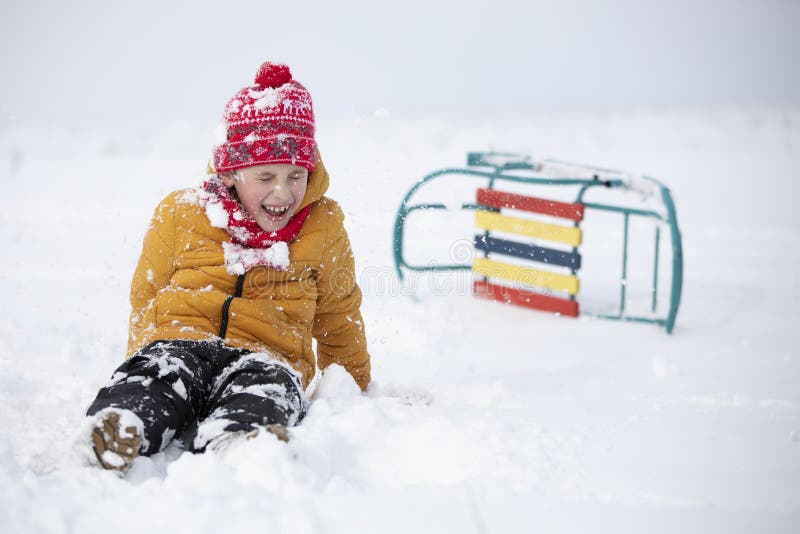 A Little Boy Fell Down Sledding and Sits in the Snow Stock Photo ...