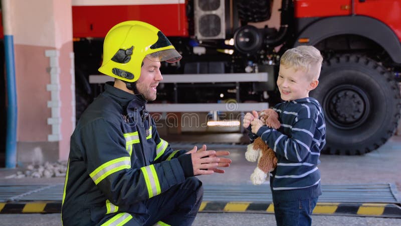 Little Boy with Firefighter in Protective Uniform in Fire Station Stock ...