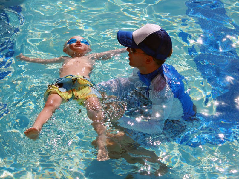 Little Boy Floating with Swim Instructor Stock Image - Image of ...