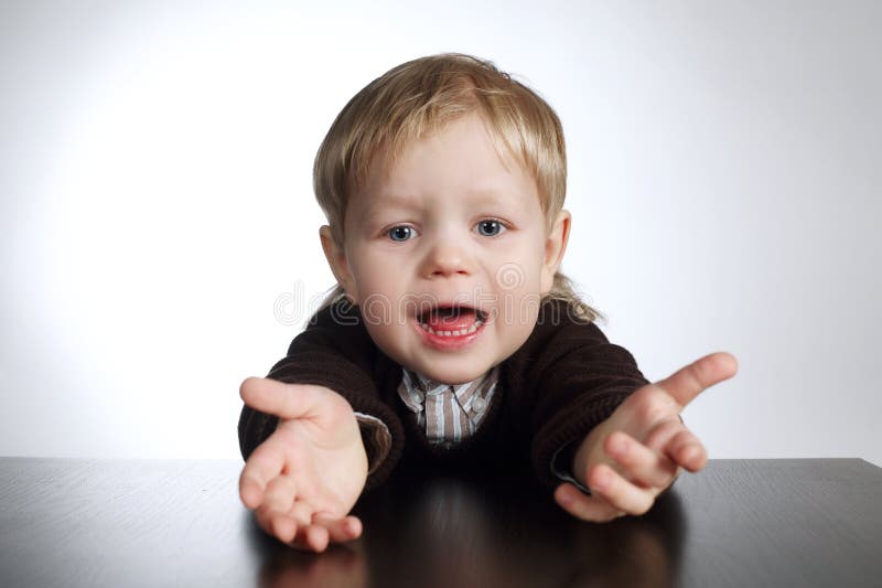 Little Boy Gesturing Sitting at Table Stock Image - Image of male ...