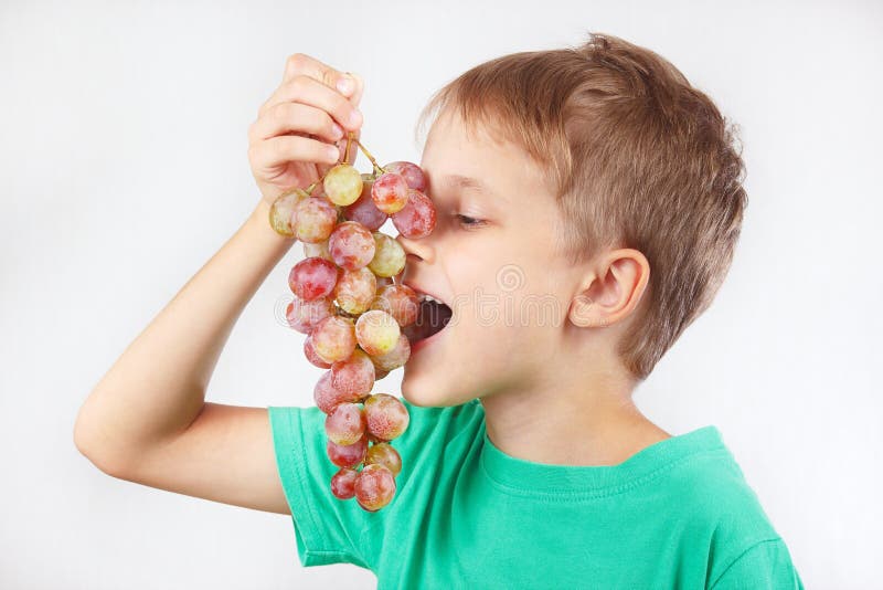 Little Boy in a Green Shirt Eating Ripe Grape Stock Photo - Image of ...