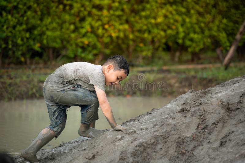 Little Boy Have Fun Playing in the Mud in the Community Fields Stock ...