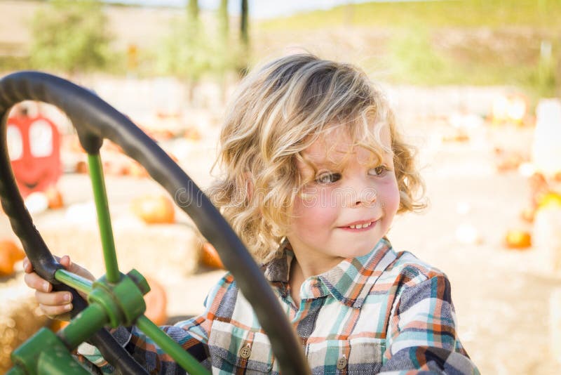 Little Boy Having Fun on a Tractor in a Rustic Ranch Setting at the ...
