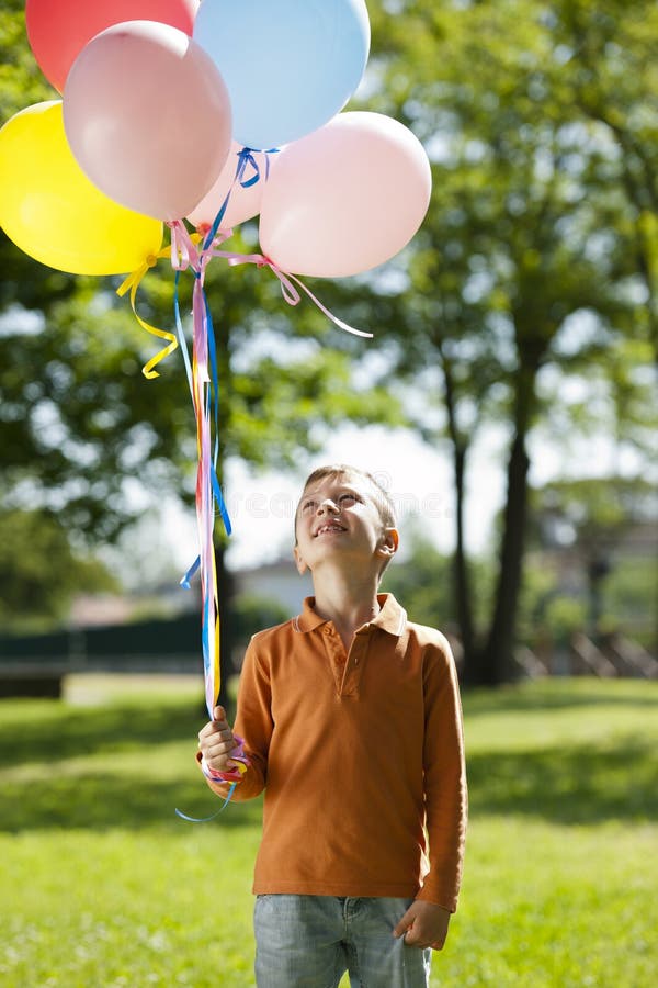 Little Boy Holding Balloons Stock Image - Image of spring, recreational ...