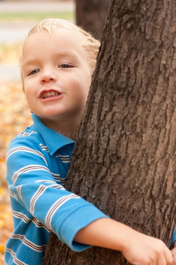Little boy hugging a tree. stock image. Image of foliage - 16214019