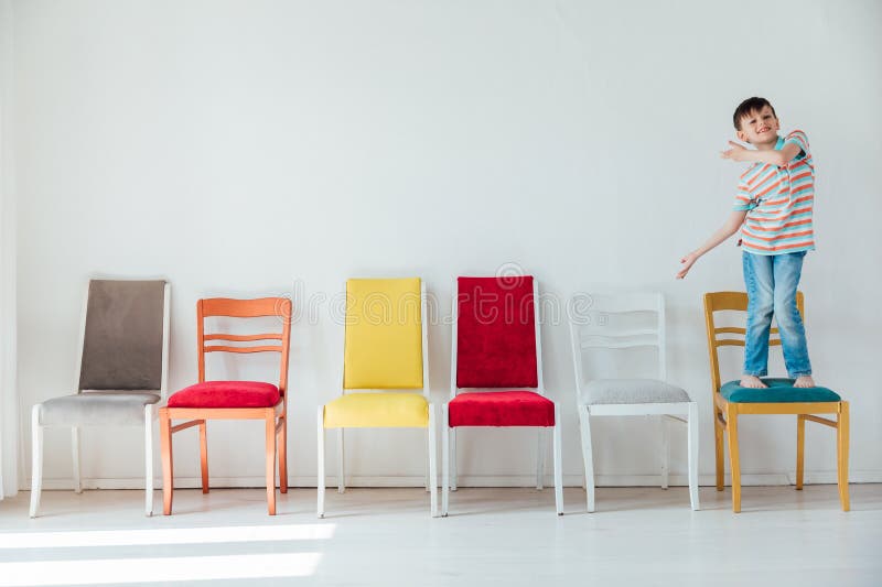Little Boy Jumping on Chairs in White Room Interior Stock Image - Image ...