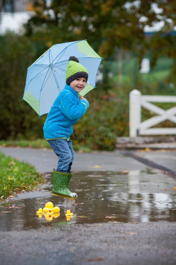Little Boy, Jumping in Muddy Puddles Stock Image - Image of boots ...