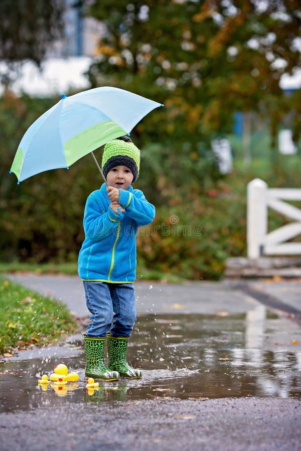 Little Boy, Jumping in Muddy Puddles in the Park, Rubber Ducks I Stock ...