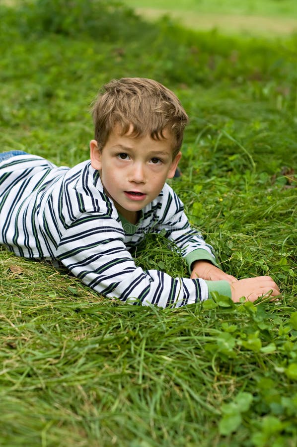 Little Boy Laying in Green Grass Stock Image - Image of looking, grass ...