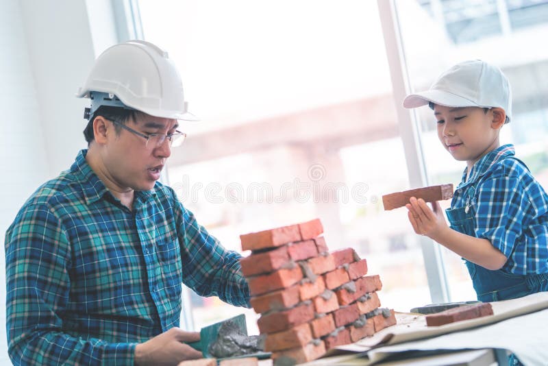 Little Boy Learning How To Build Brick Wall from His Construction ...