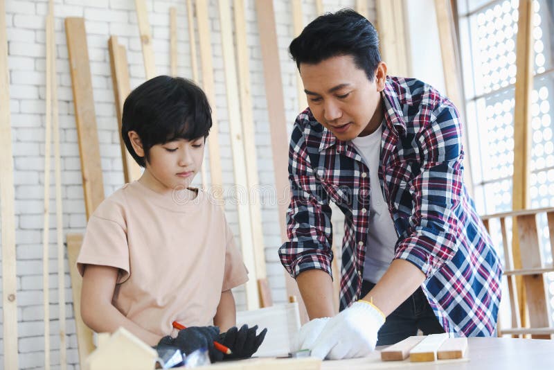 Little Boy is Learning To Work on Wood. Father and Son are Working on ...
