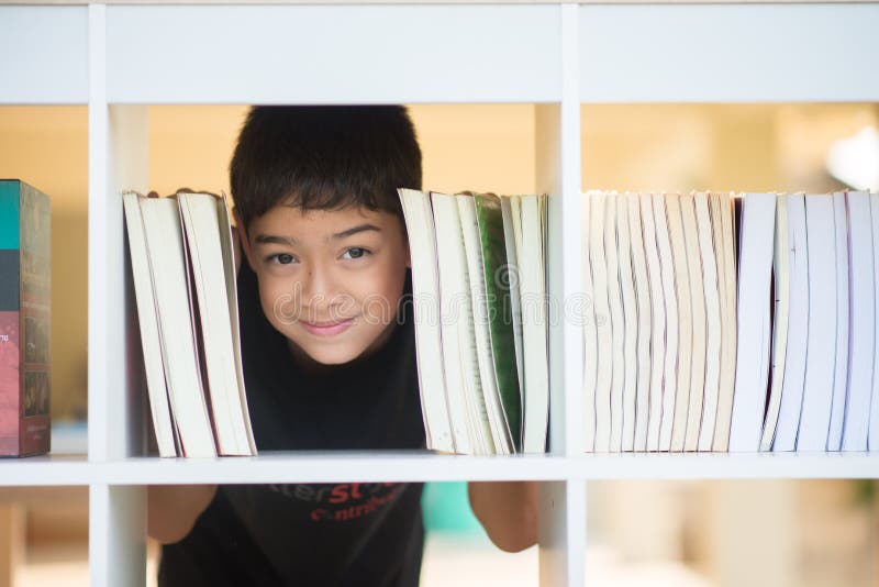 Little Boy in the Library at School Face between Books Stock Photo ...