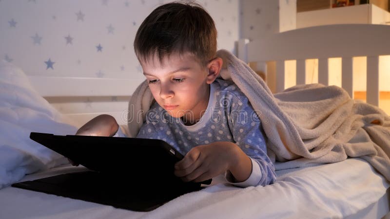 Little Boy Lying in Bed before Going To Sleep and Browsing Video on ...