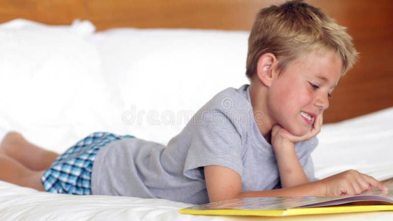 Little Boy Lying on Bed Reading a Book Stock Video - Video of home, cushions: 43317541