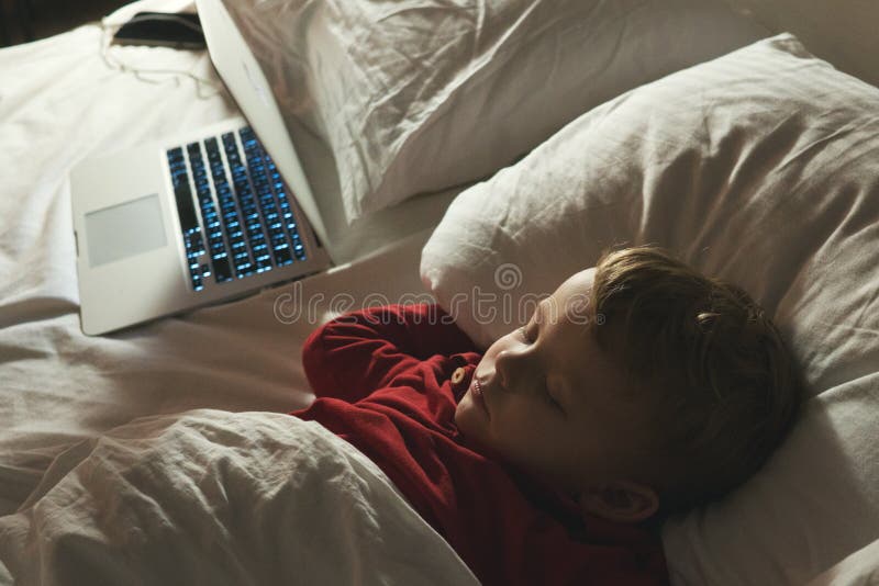 Little Boy Lying and Sleeping on the Bed with Laptop at Night. the ...