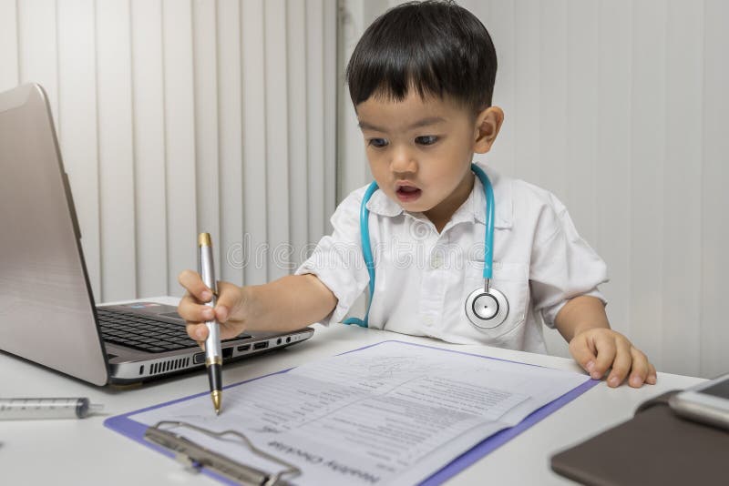 Little Boy in Medic Uniform Using a Pen on Desk Stock Image - Image of ...