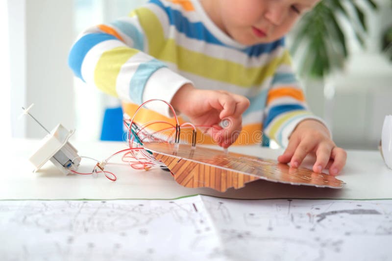 Little Boy Performing or Studying Science with Wires, Connections ...