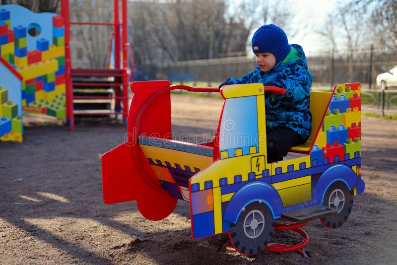 The Little Boy at a Playground Plays on the Children S Machine Stock ...