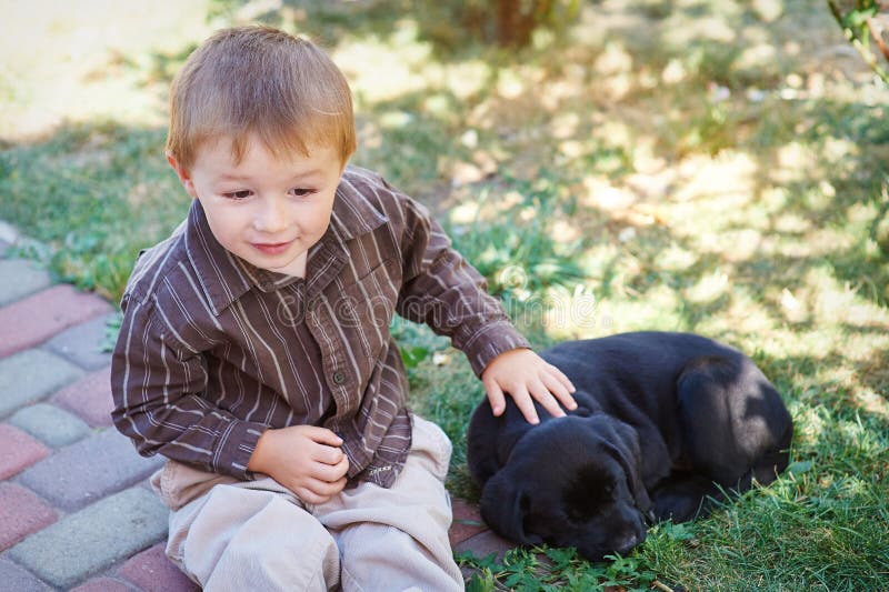 Little Boy Playing with a Black Labrador Puppy Stock Photo - Image of ...