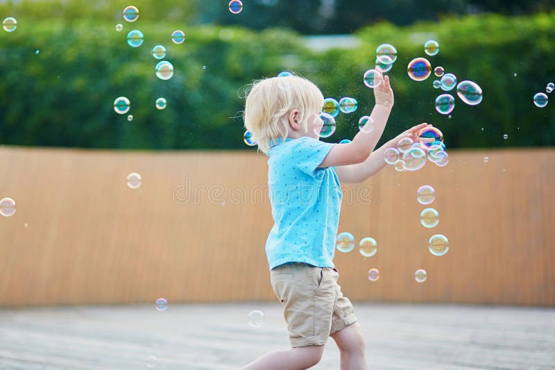 Little Boy Playing with Bubbles Outdoors Stock Photo - Image of blond ...