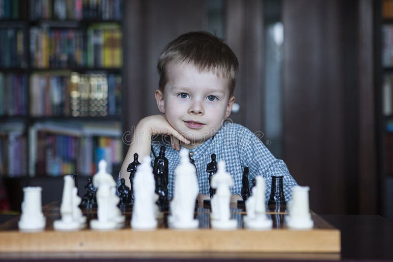 Little boy playing chess. stock photo. Image of little - 185797436