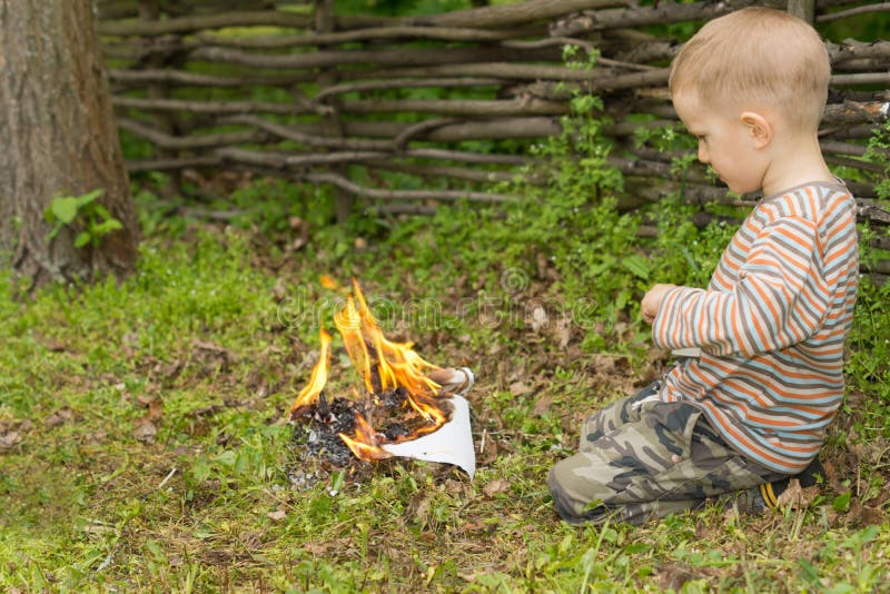 Little Boy Playing with Fire Stock Photo - Image of small, sitting ...