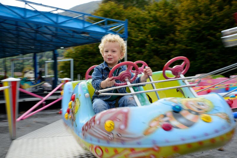A Little Boy Playing In A Fun Fair Carousel Stock Image - Image of ...